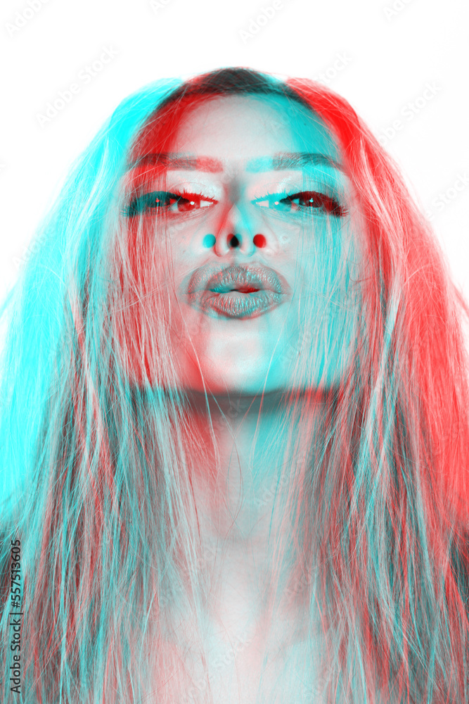 Studio portrait of sexy woman with messy hairstyle sending kiss to camera in red and blue color ...