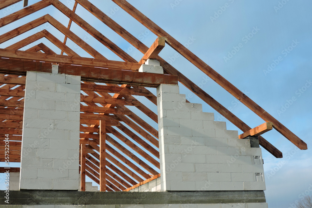 A timber roof truss in a house under construction, walls made of ...