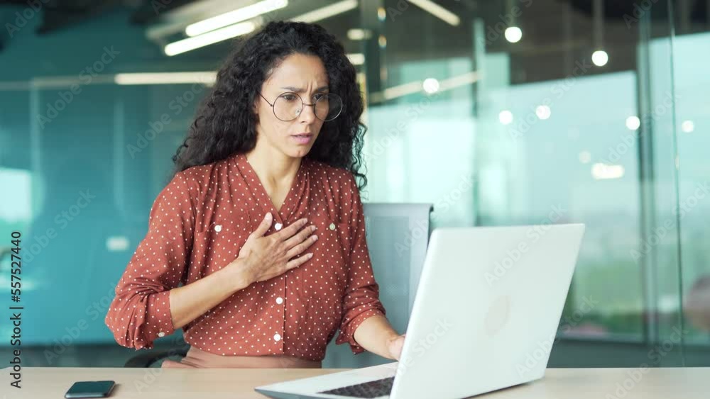 Young latin female office worker having panic attack at workplace ...