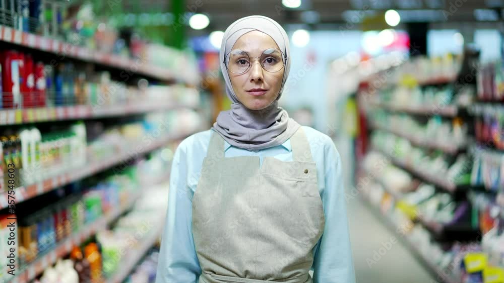 Portrait Muslim woman in hijab worker in supermarket grocery store or ...