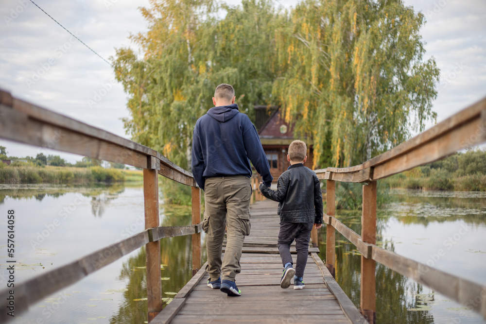 Happy father and son hugging and playing together in green nature ...