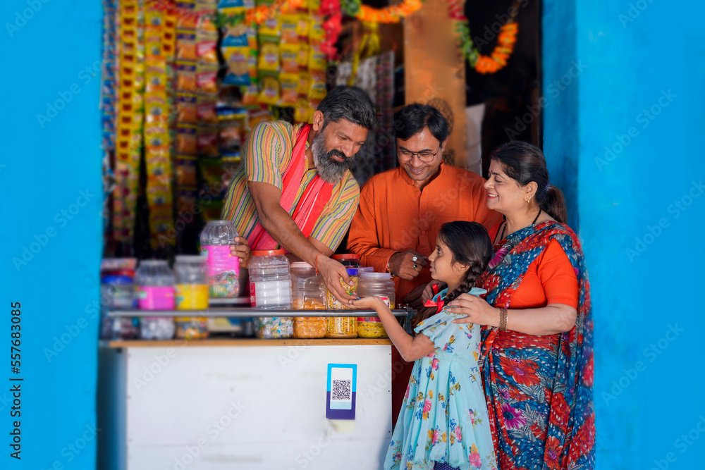 Indian little girl child purchasing some item with his mother at ...