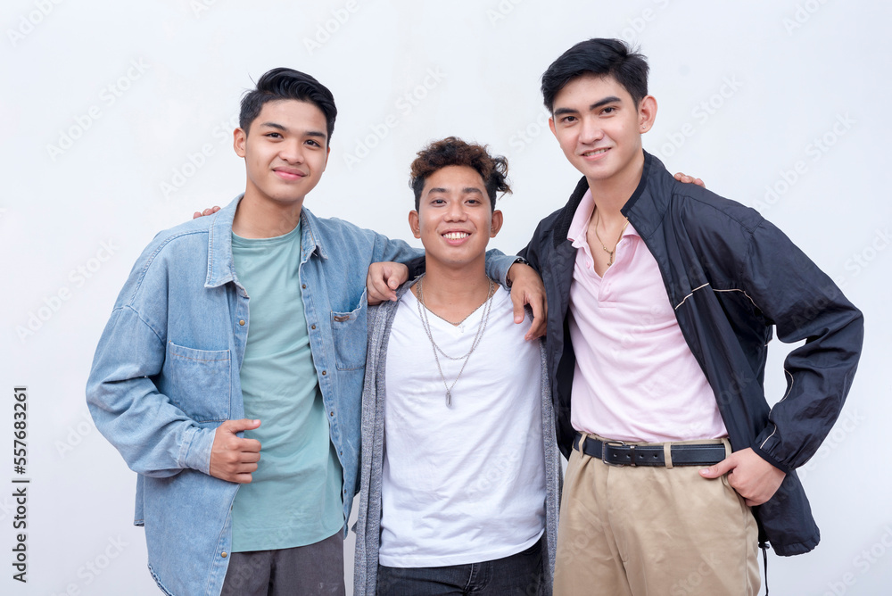 Three male friends posing together. Wearing casual wear posing against ...