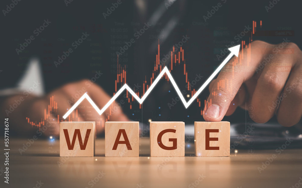 Businessman pointing finger at word WAGE on wooden block. Wage concept ...