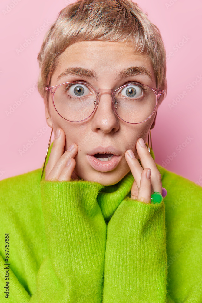 Headshot of stunned shocked woman keeps hands on cheeks holds breath ...