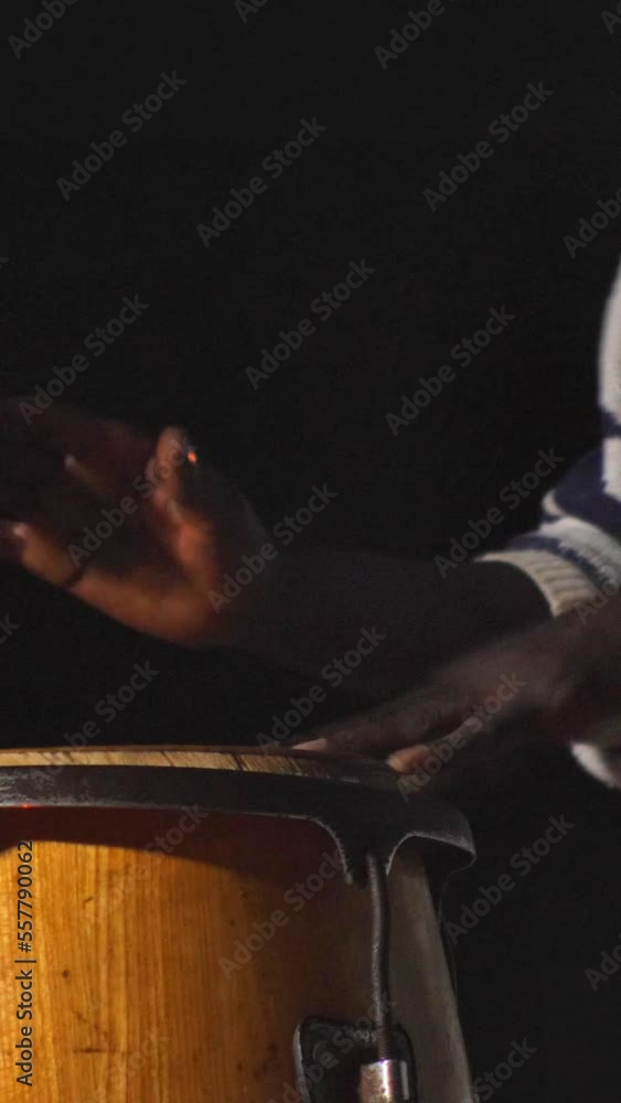 Vertical video of Black man standing playing conga drums in front of ...