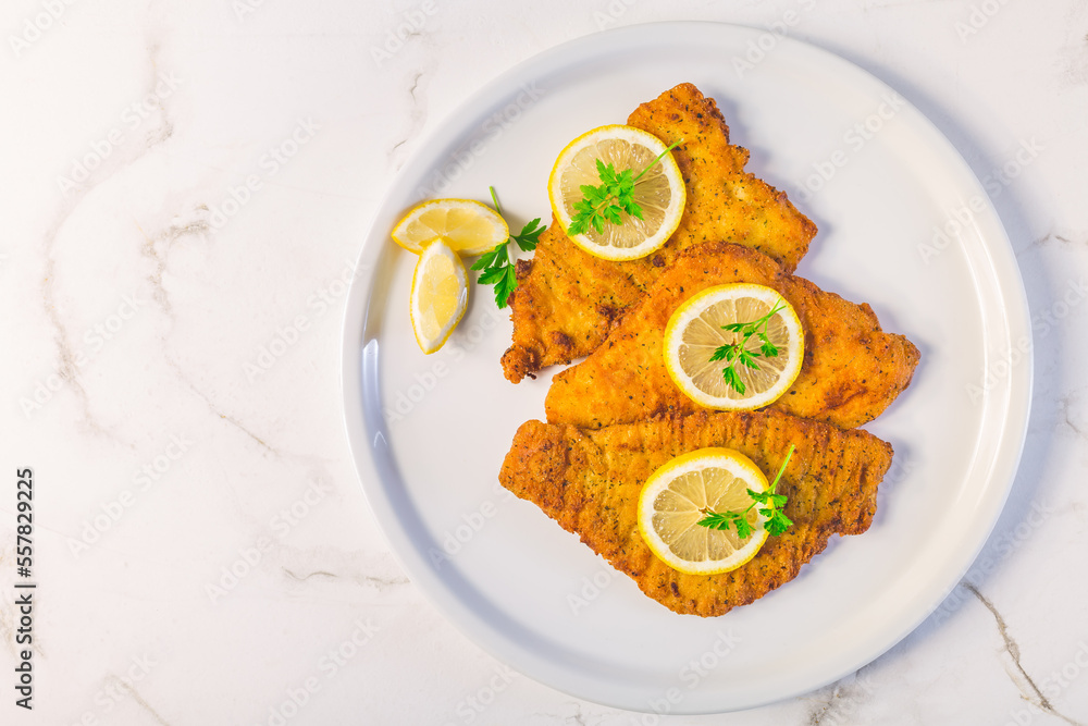 Breaded fish, baked and served with lemon. Common dab, edible flatfisch ...