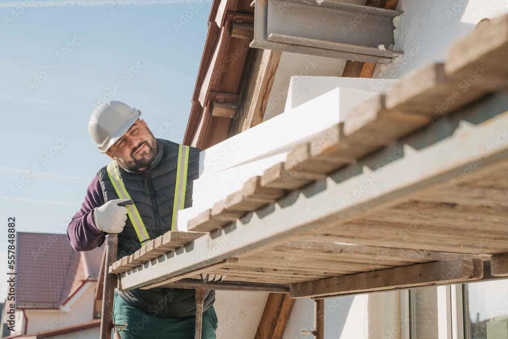 Construction worker with polystyrene foam working at site Stock Photo ...