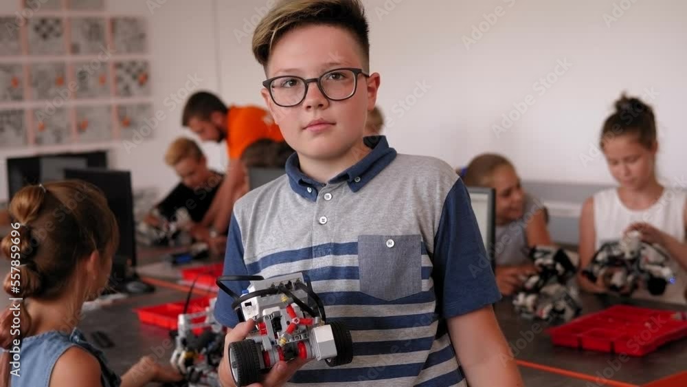 Vidéo Stock Portrait of a happy schoolboy boy with a robot that he ...