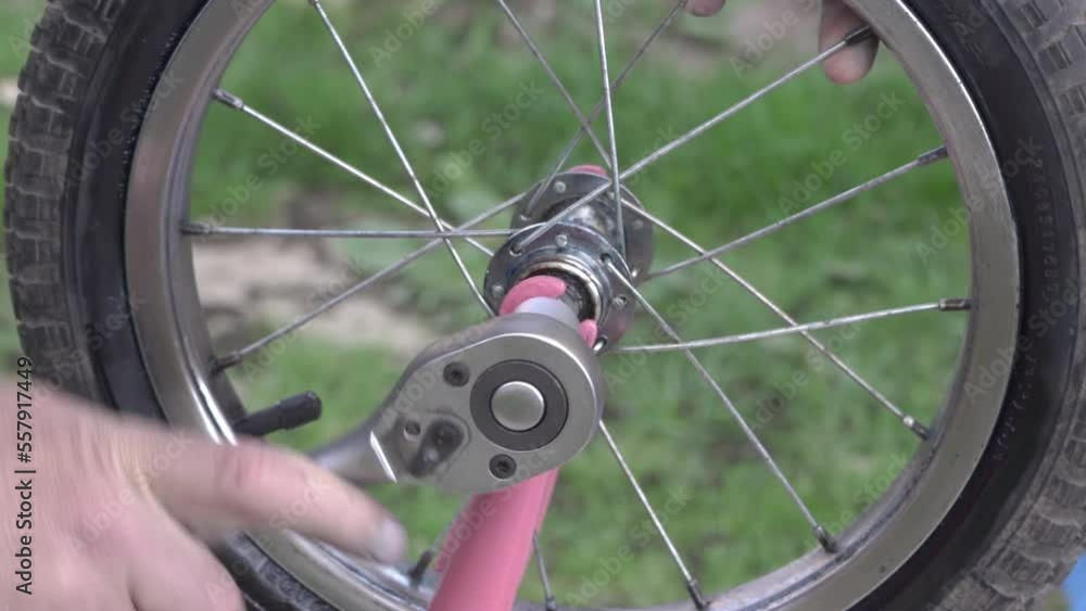 Turns the bicycle wheel with a key,screw the nut on the bicycle wheel ...