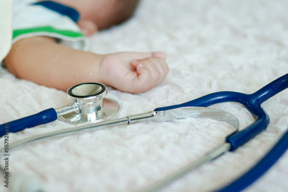 Foto de A stethoscope is placed on a bed near a male infant. Baby ...