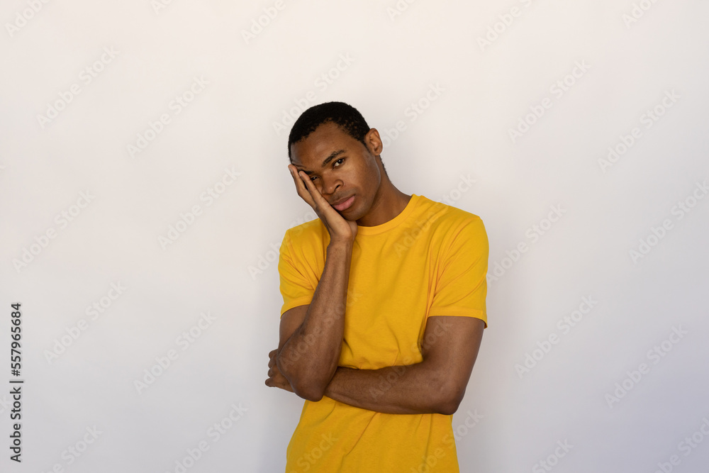 Bored young man holding his face with hand. Male African American model ...
