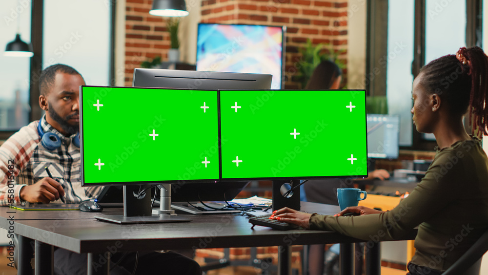 Foto de Creative agency employee using greenscreen display on computer ...