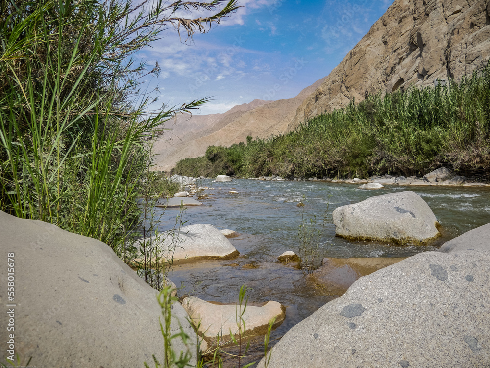 Foto de Rio rodeado de rocas, montañas y vegetación con cielo azul y ...