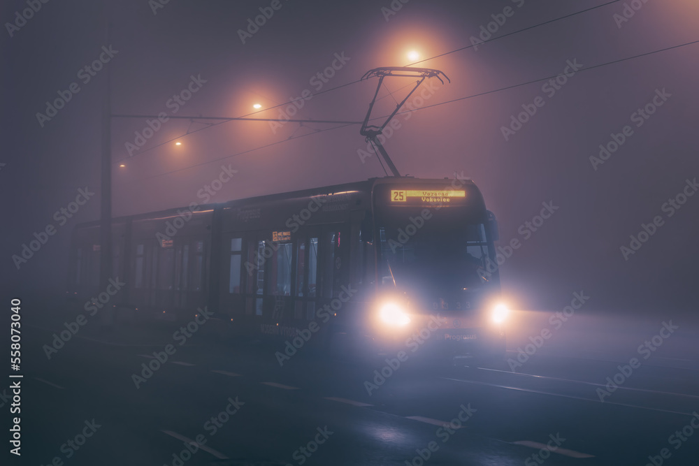 Foto de Prague tram during heavy evening fog. City lights and darkness ...