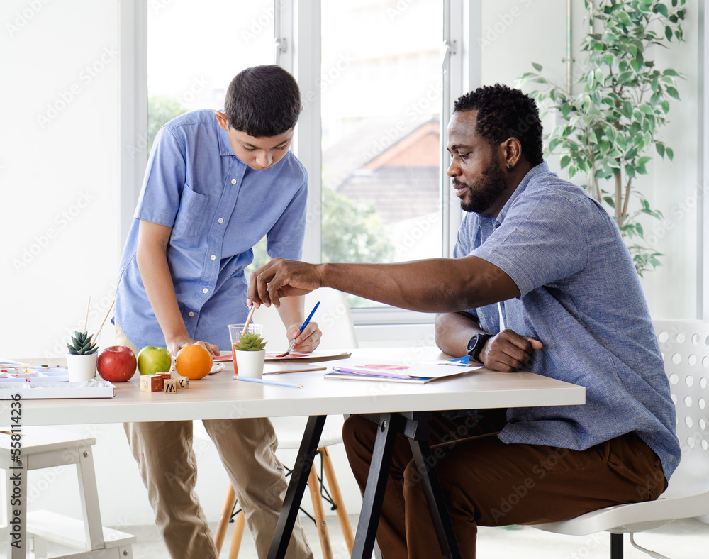 African American teacher and child student studying in classroom ...