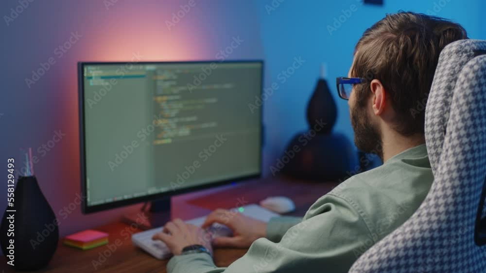 Man programmer typing on a keyboard code. back view. Focus on the ...