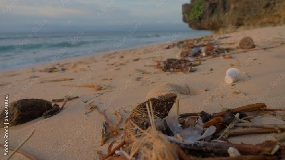 Close-up slow motion video of plastic trash on a wild sand beach in ...