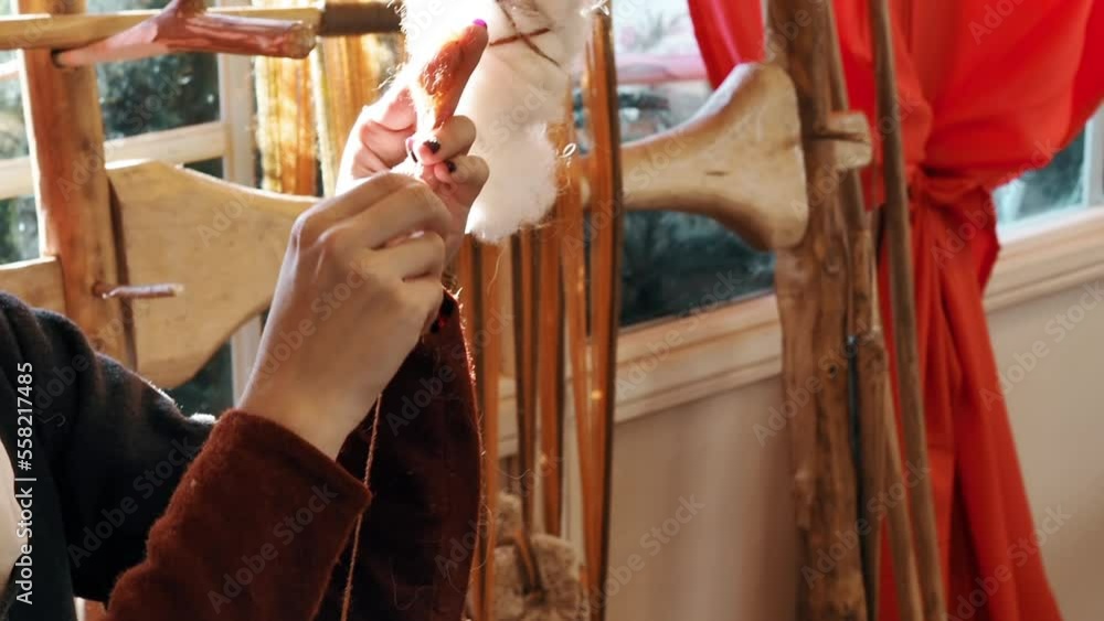 Woman in medieval cotton dress spinning with a spindle. Lady makes yarn ...