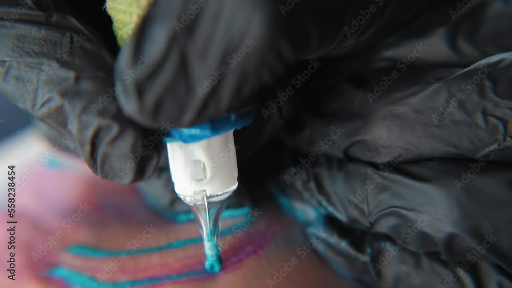 Tattoo artist girl at work.A feminist with dreadlocks gets a tattoo.A ...