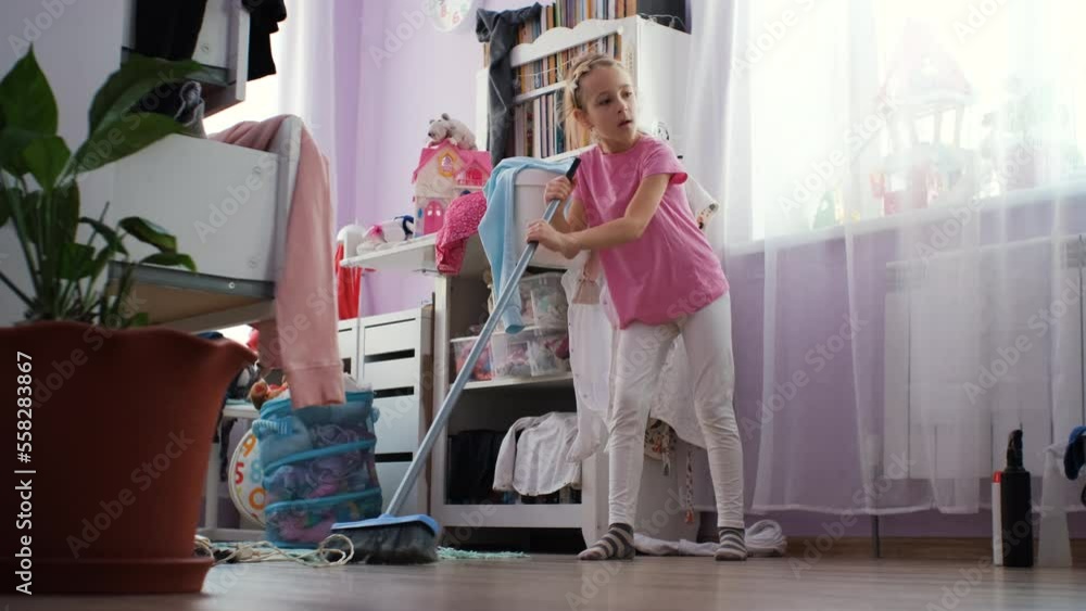 Little girl sweeping the floor with a broom at home. Concept of ...