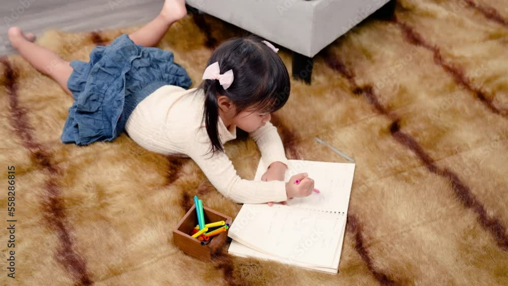 4K, Young cute Asian girl, Lie prone on carpet in living room of house ...