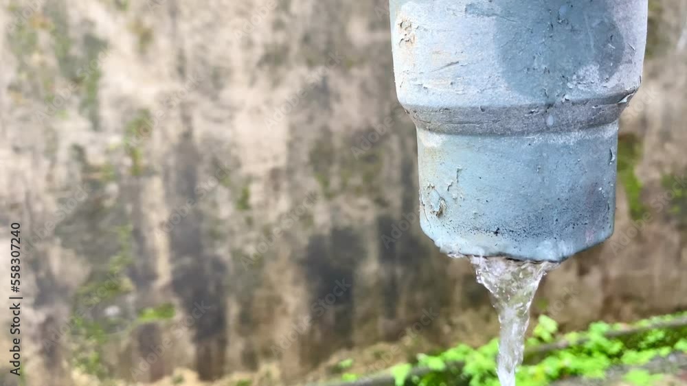 Close Up water flows out through the pipe. flows of water pours out of ...