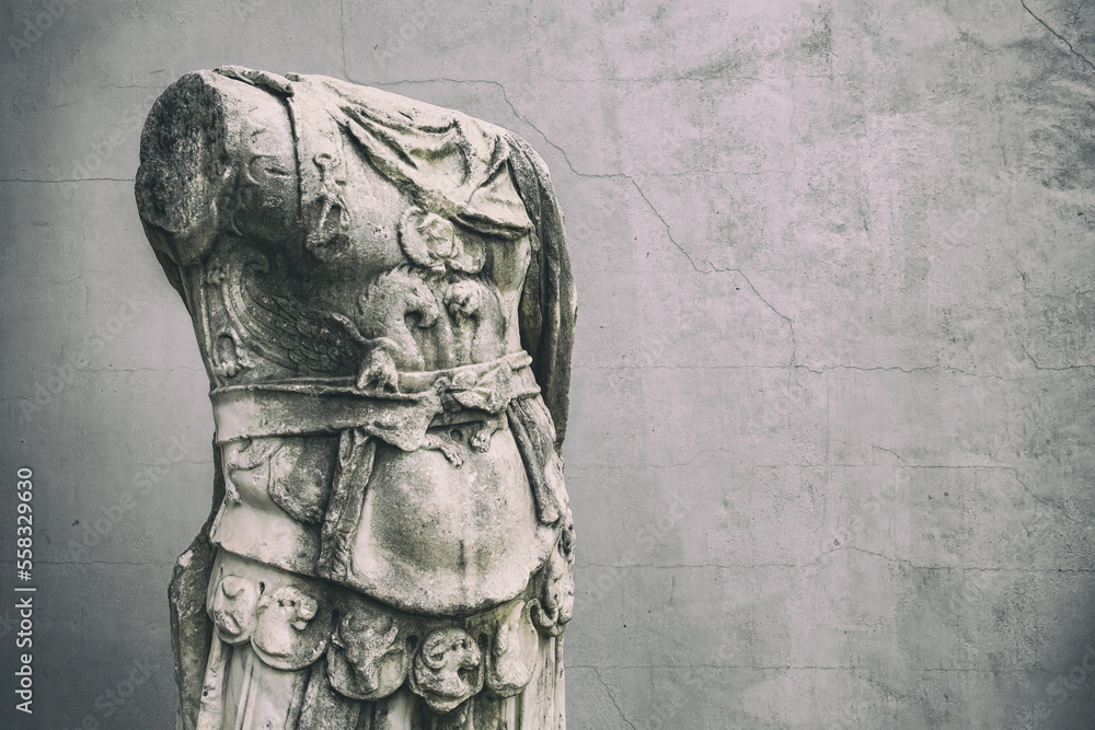 Emperor's armor close-up on an ancient Roman marble statue. Grunge wall ...