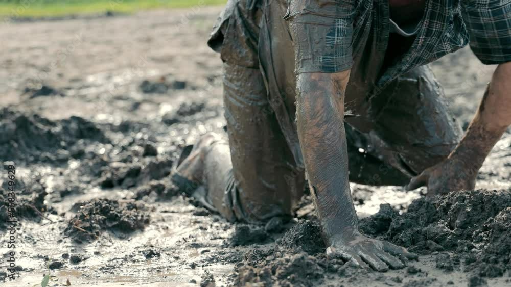 A drunken unfortunate man crawls through the swamp in dirty clothes. A ...