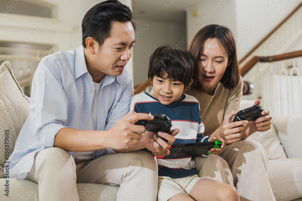 happy Asian family, dad playing game with son and mom at home Stock ...