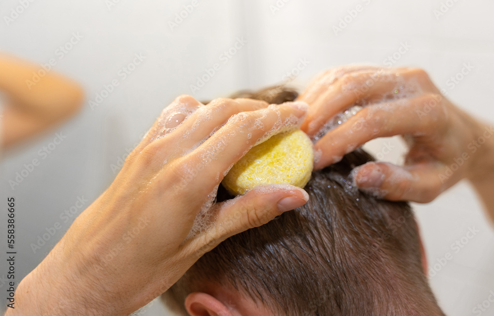A man applies a solid shampoo bar to the hair. Sustainable hair care ...