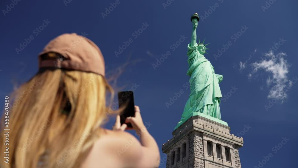 Low Angle Shot Of A Woman Taking A Picture Of The Statue Of Liberty ...