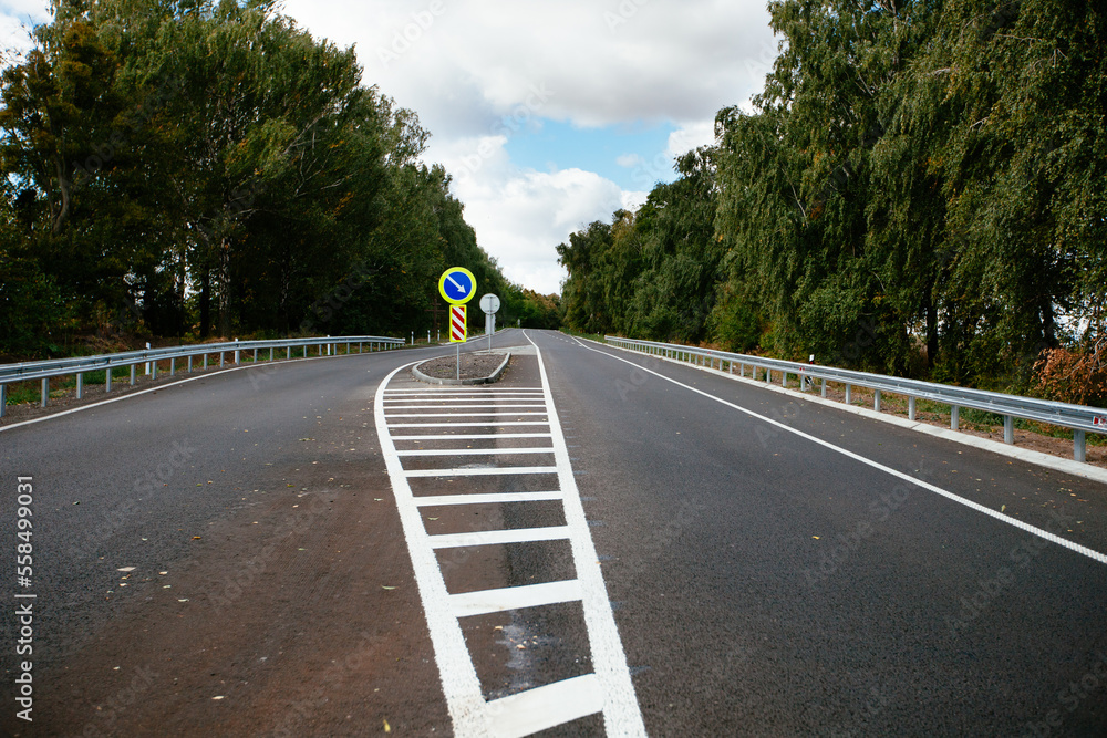 New asphalt road with markings and road signs in the sun's rays Stock ...