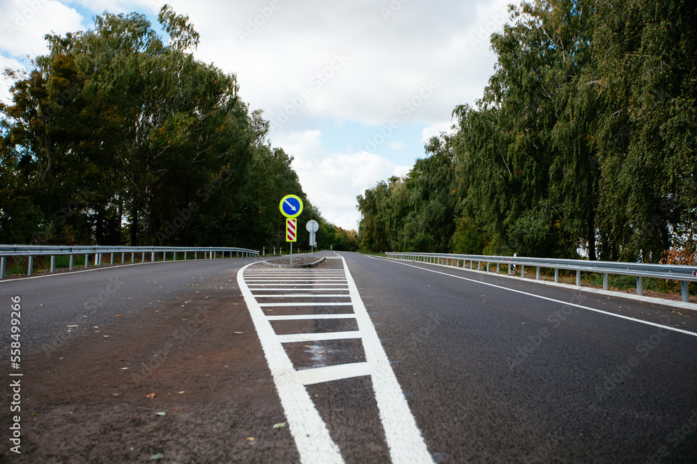 New asphalt road with markings and road signs in the sun's rays Stock ...