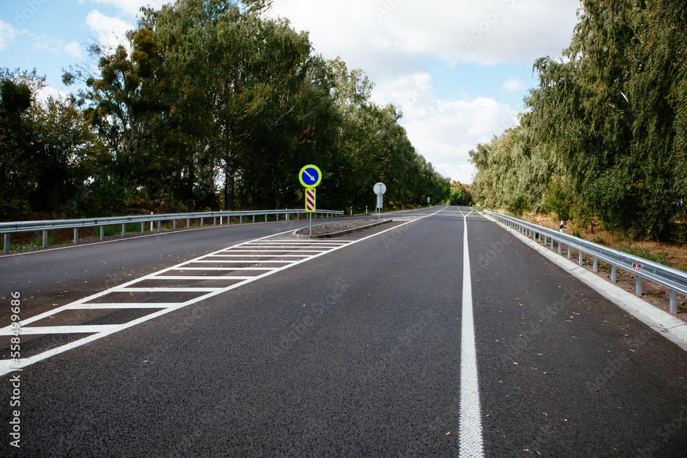 New asphalt road with markings and road signs in the sun's rays Stock ...