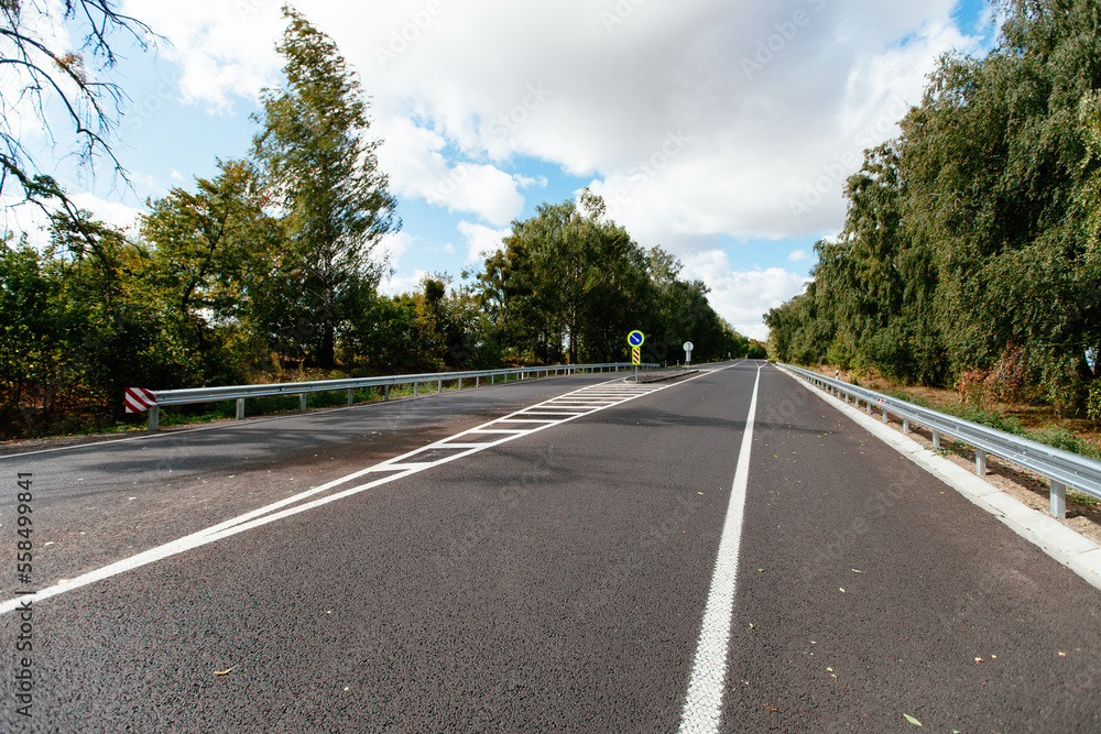 New asphalt road with markings and road signs in the sun's rays Stock ...