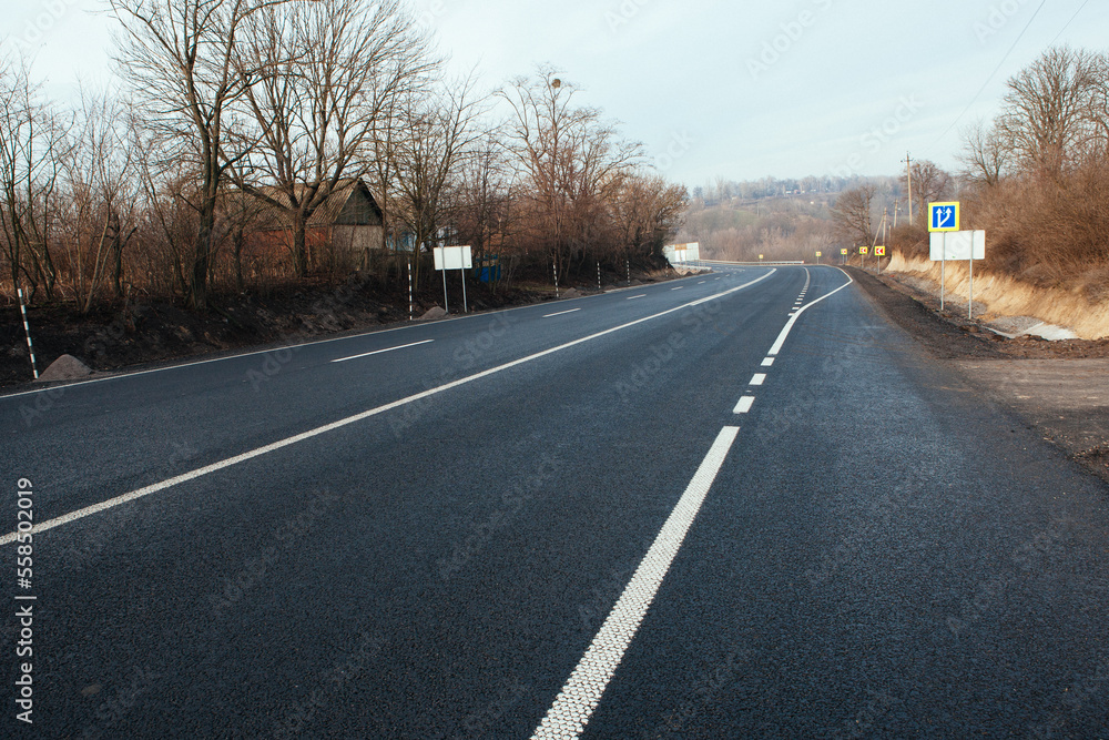 New asphalt road with markings and road signs in the sun's rays Stock ...
