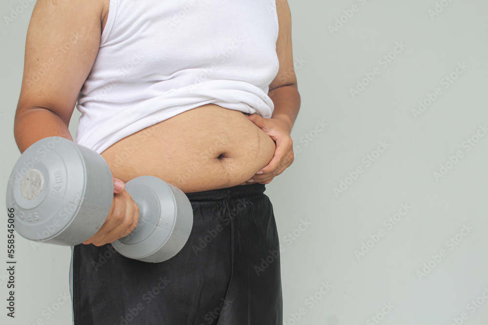 Overweight fatty belly of man and holding a dumbbell. Man diet ...