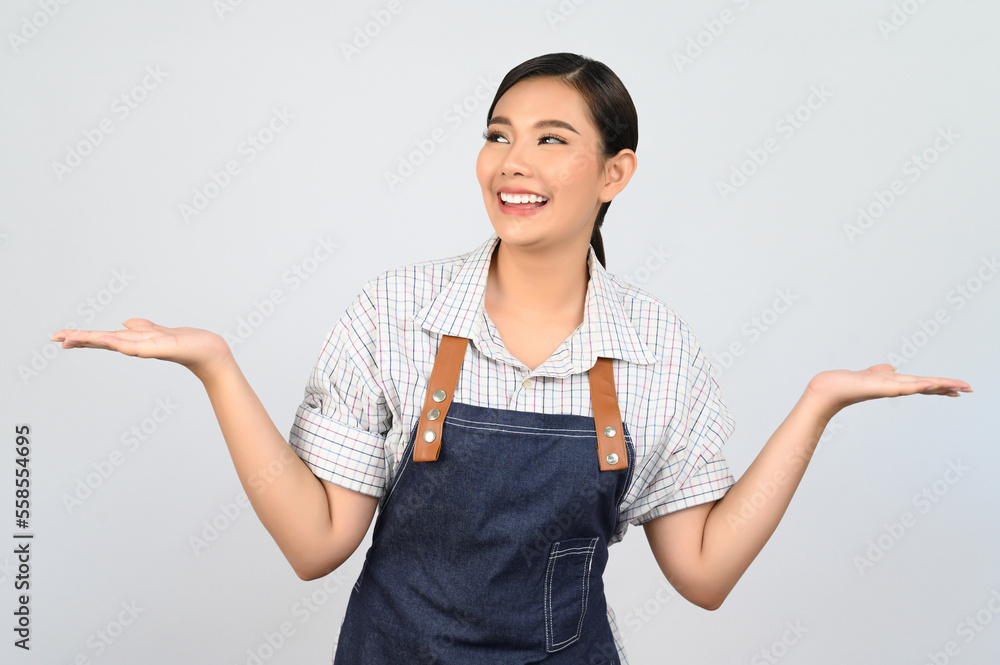 Portrait Asian young woman in waitress uniform with open palm posture ...