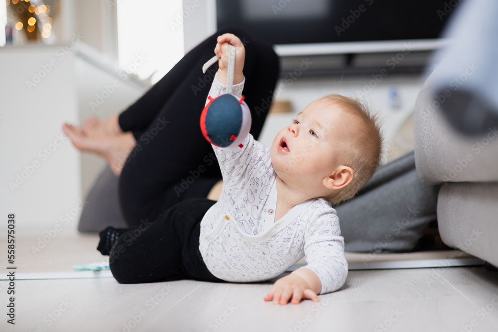 Happy family moments. Mother lying comfortably on children's mat ...