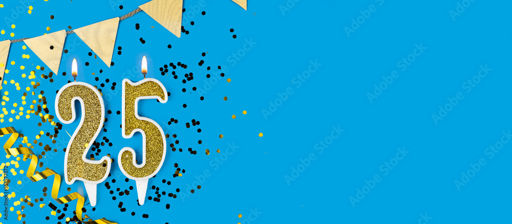 Number 25 gold celebration candle on star and glitter blue background ...