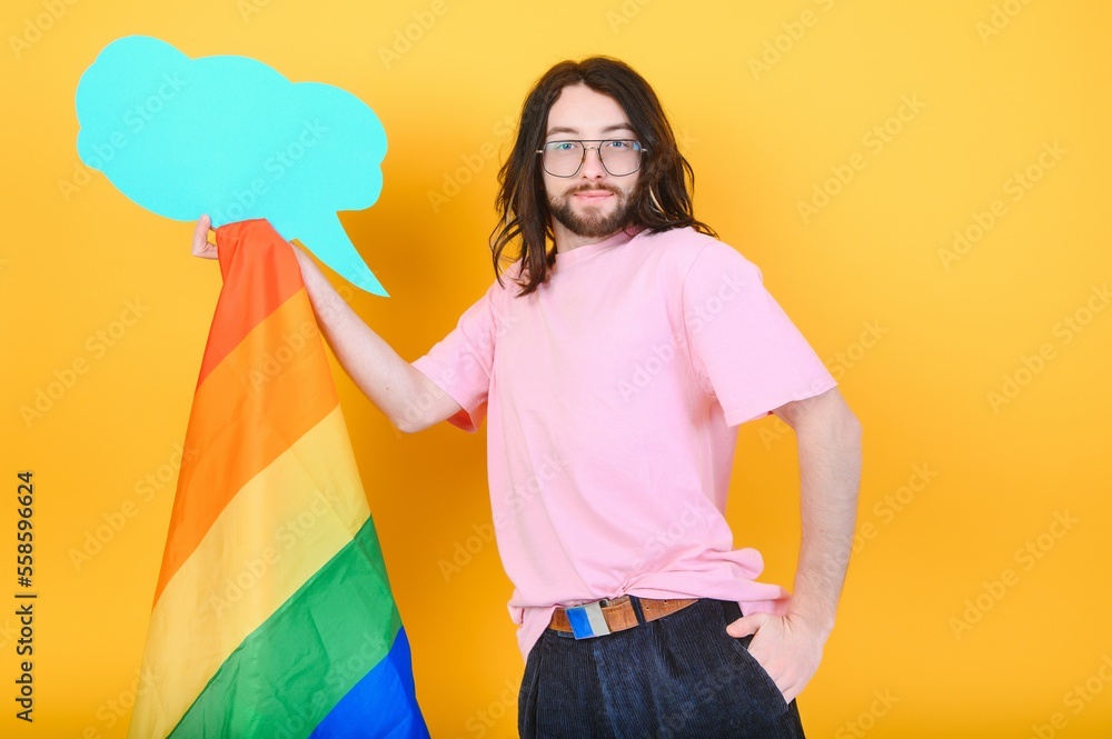 Handsome young man with pride movement LGBT Rainbow flag on shoulder ...