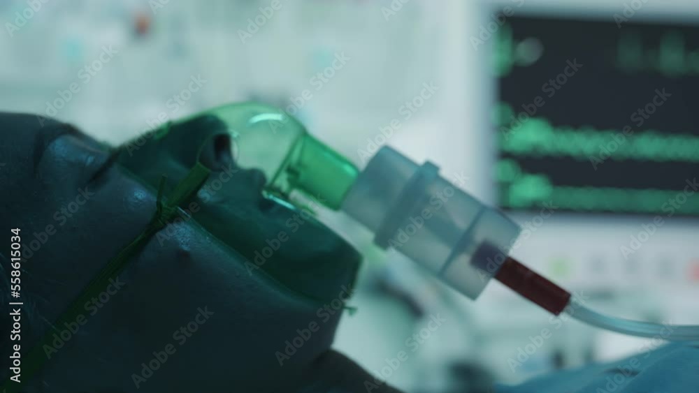 A female patient in medical mask is breathing oxygen support in a ...