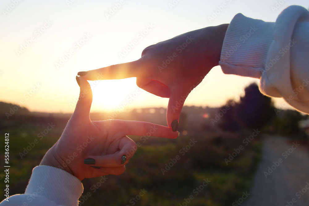 woman's hand creates a frame in front of the sun. idea of vision and ...