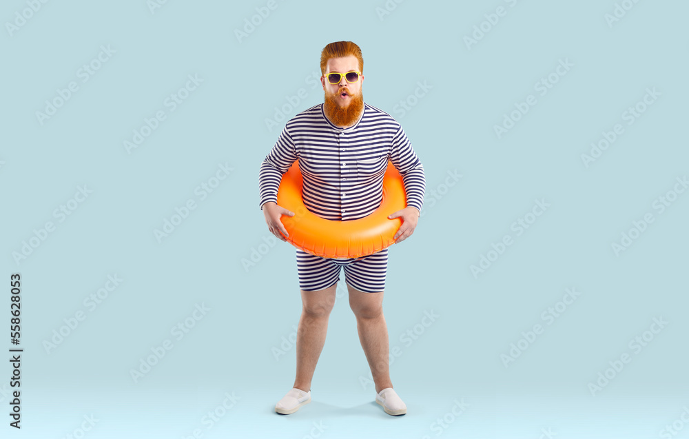 Funny chubby male swimmer with inflatable swimming circle looks at ...