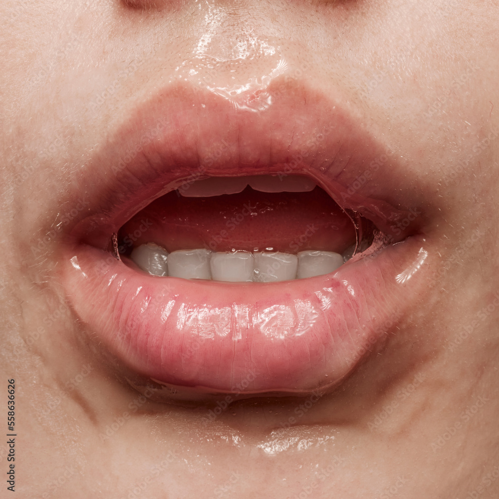 Breath. Closeup of beautiful sensual woman's lips covered with honey ...
