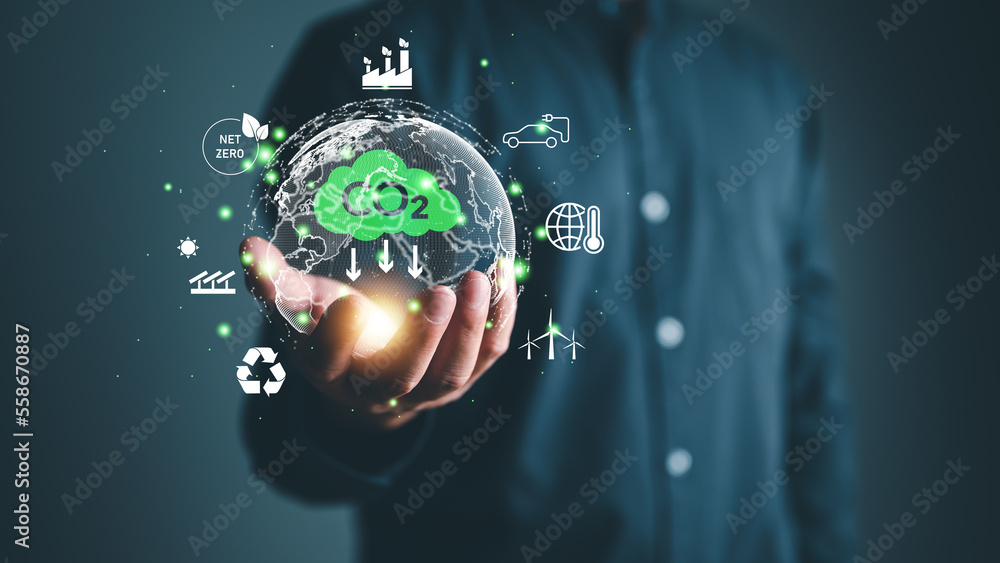 Hand holding virtual Global with CO2 reducing icon for concept of decrease carbon dioxide ...