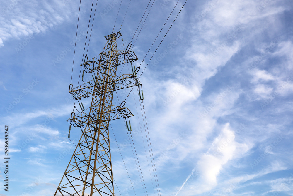 High voltage tower with electrical wires on blue sky with white clouds ...