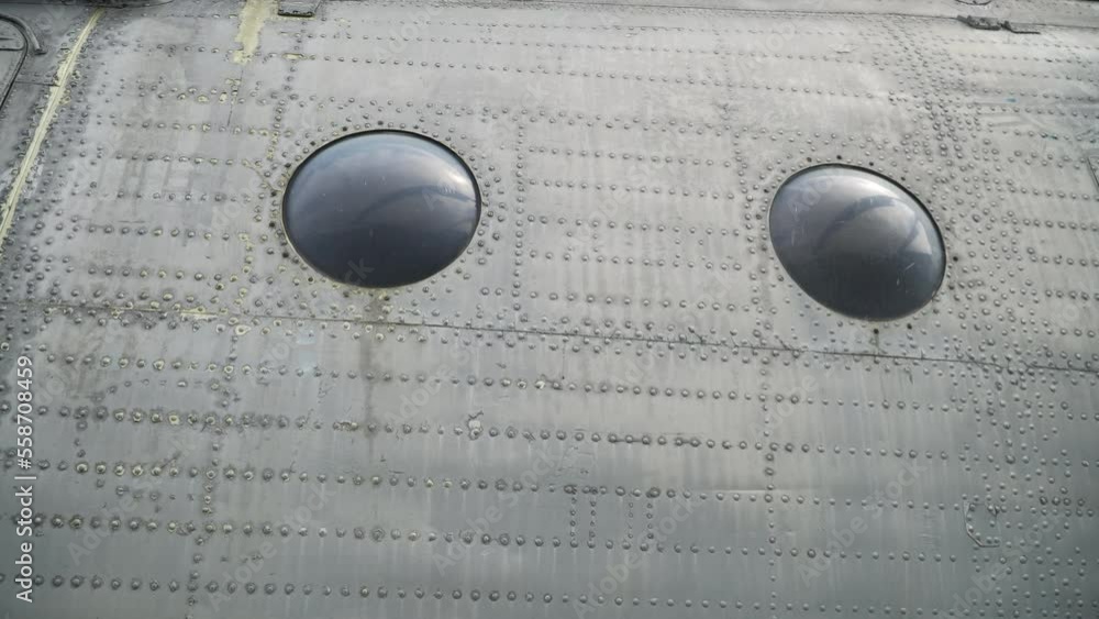 Military aircraft body, metal sheets with rivets, portholes and rusty ...