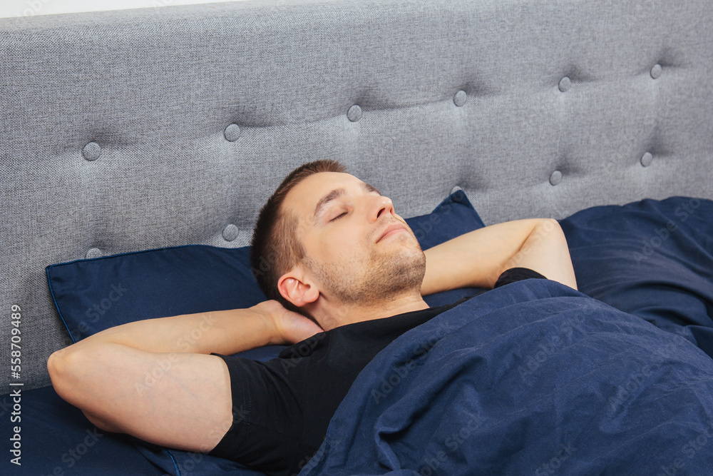 Top view of a handsome young man sleeping comfortably on the bed at ...